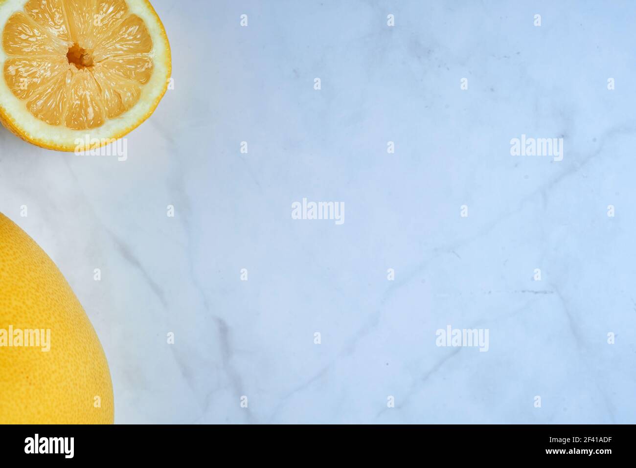 Top view of fresh lemons on kitchen marble. Grapefruit, open lemon and ...