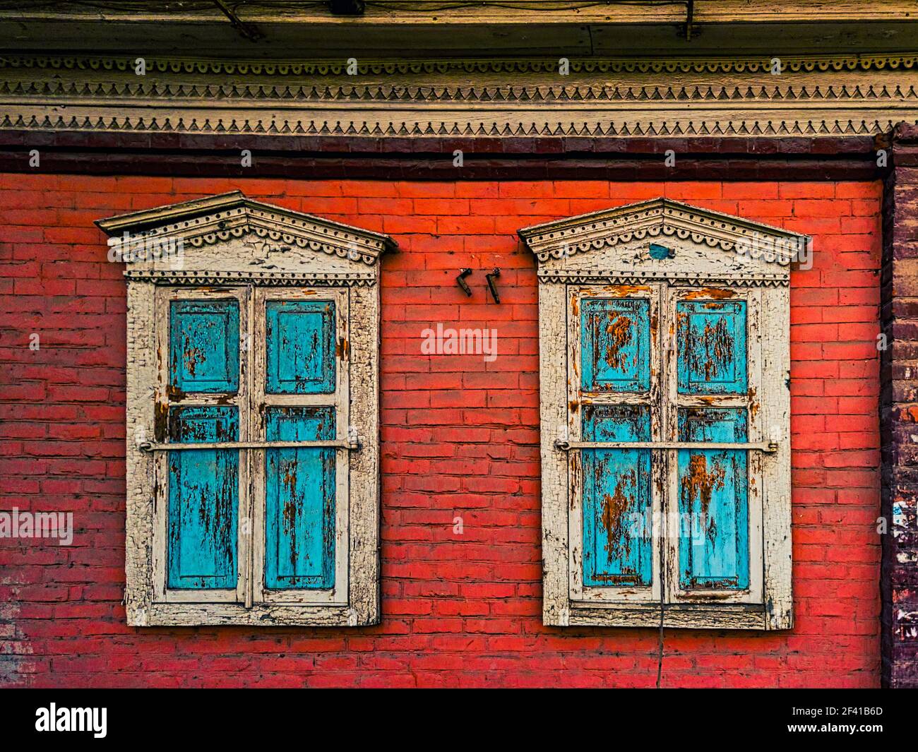 Closed wooden shutters on the windows in the red brick wall of the ...