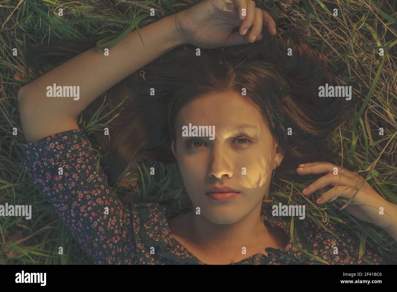 Calm face of the nice girl resing in autumnal grass Stock Photo - Alamy