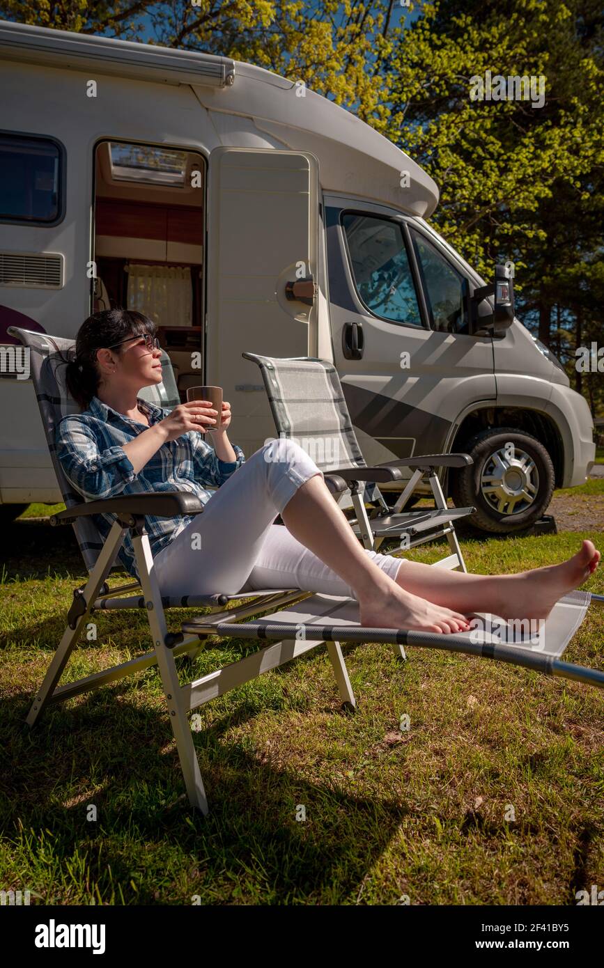Woman is standing with a mug of coffee near the camper. Caravan car ...