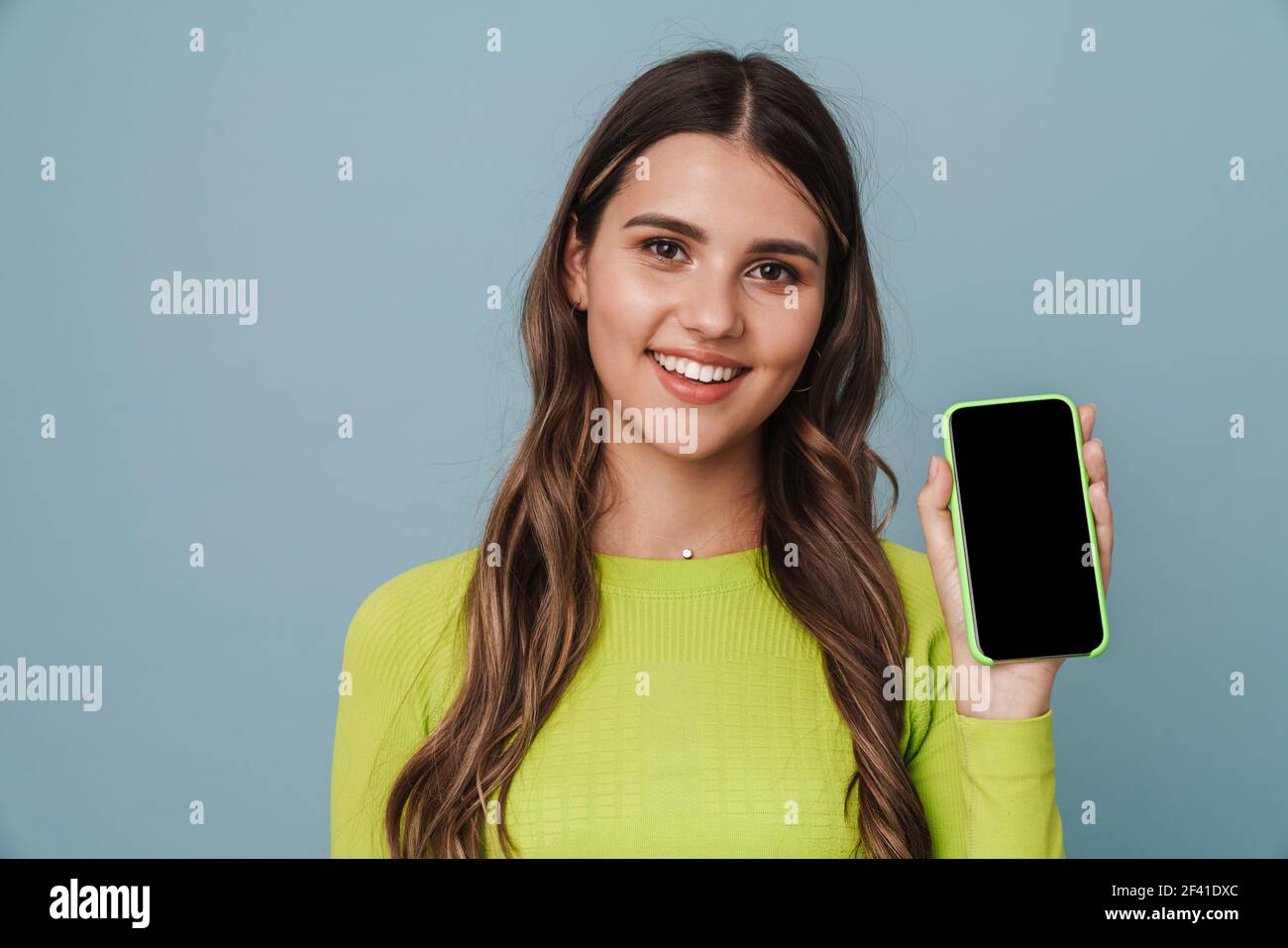 Happy beautiful cute girl smiling and showing mobile phone isolated ...