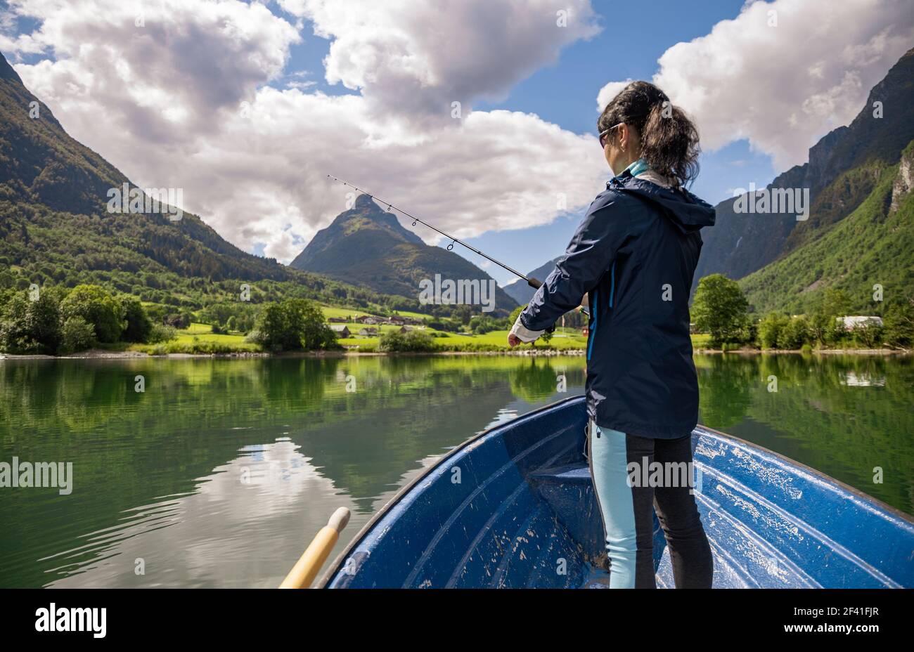 Woman fishing on a boat. Beautiful Nature Norway natural landscape ...