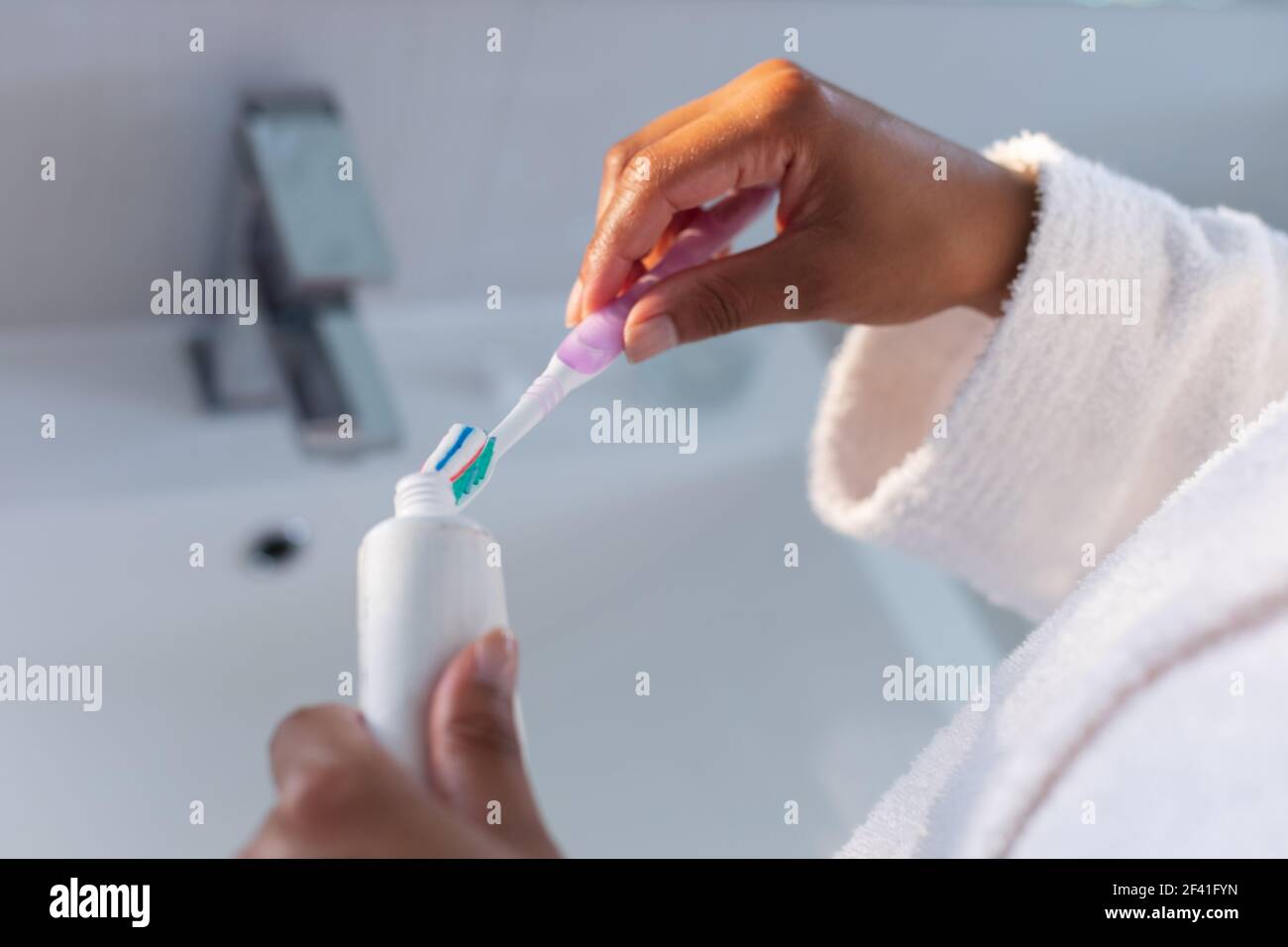 Mid section of putting toothpaste on toothbrush in bathroom Stock Photo ...