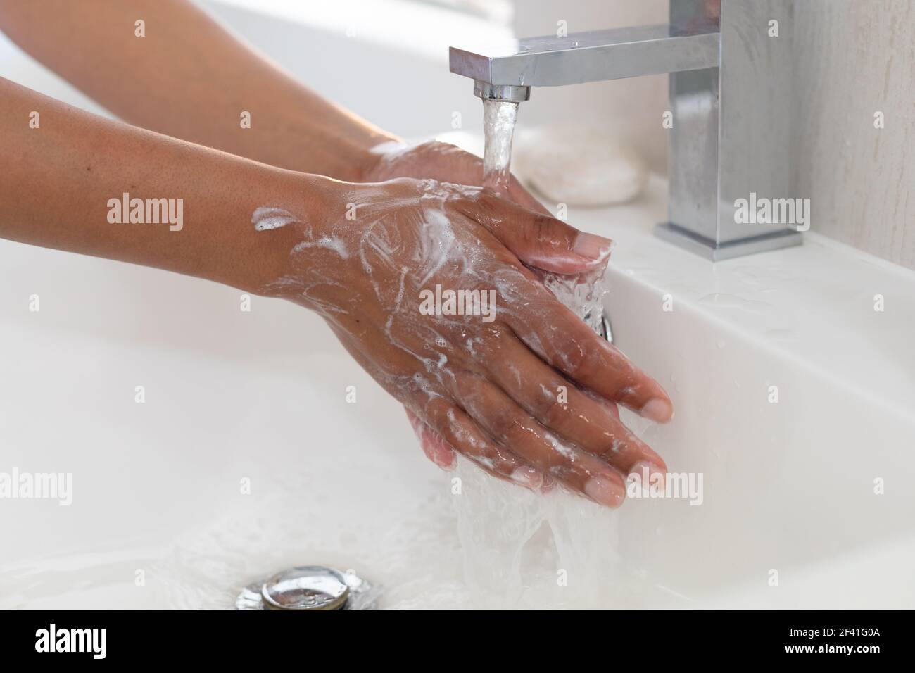 Mid section of woman washing her hands in the sink at bathroom Stock ...