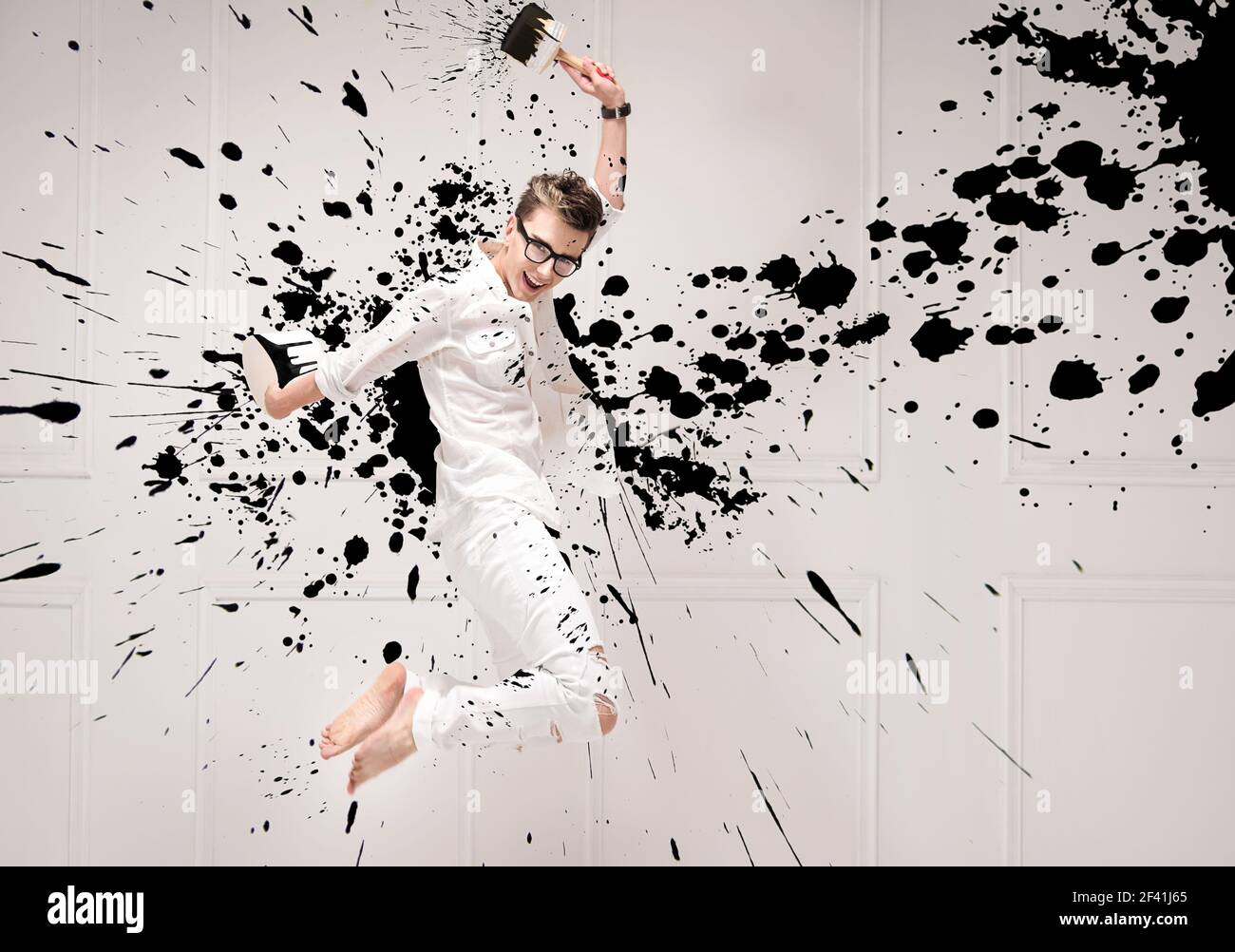Conceptual portrait of a young jumping painter Stock Photo - Alamy