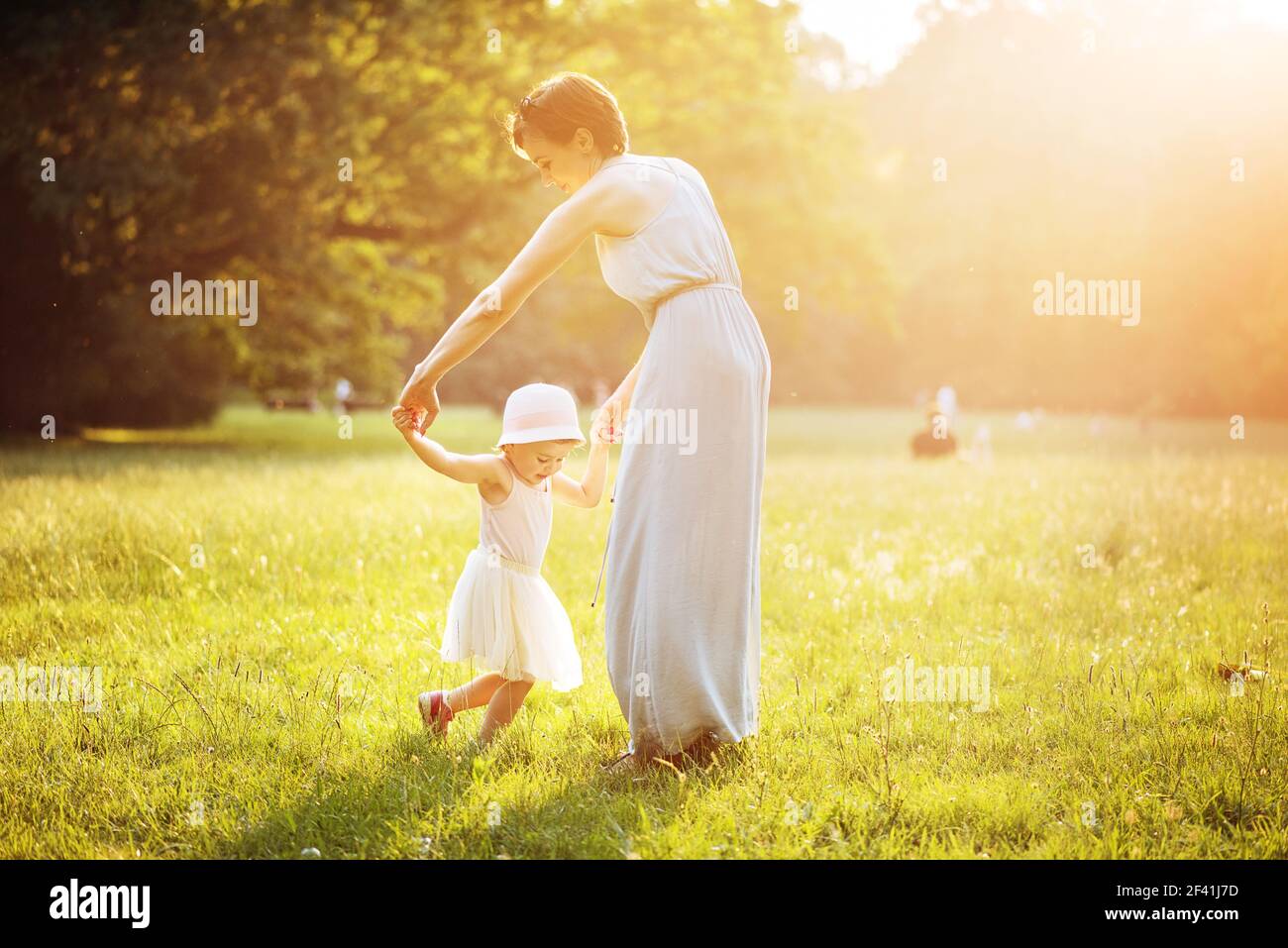 Attractive mother dancing with her daughter on the meadow Stock Photo ...