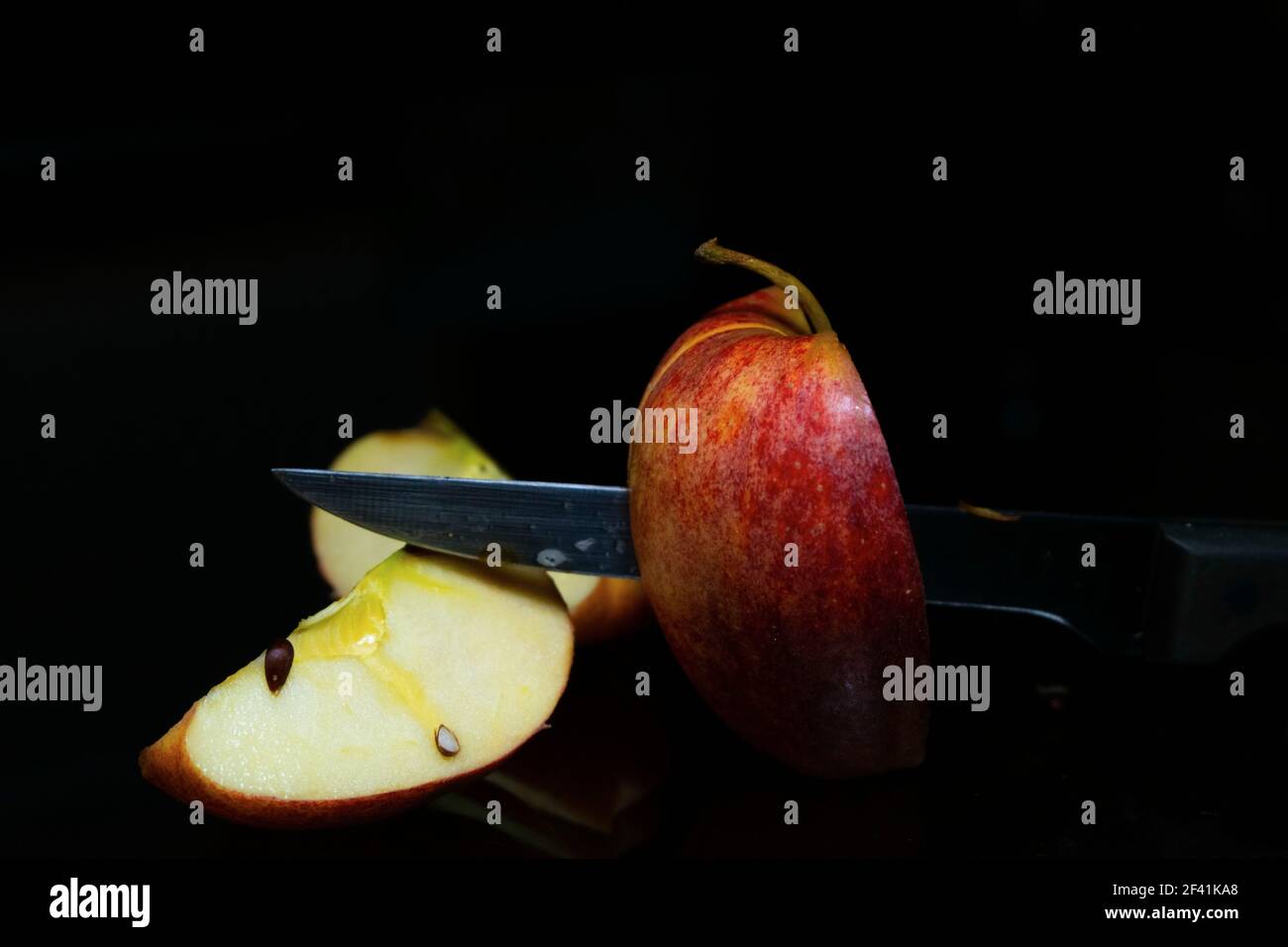 Red apple cut on black background with reflection Stock Photo - Alamy
