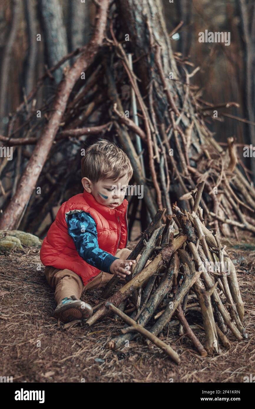 Cute little boy building a wooden hut Stock Photo - Alamy
