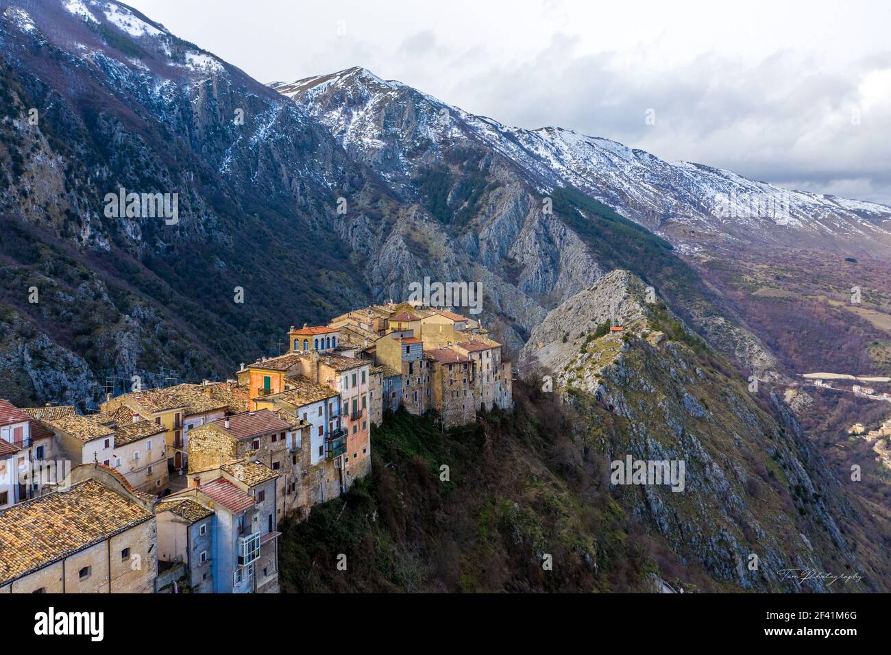 aerial view of medieval quarters in Abruzzo atop a mountain peak, with ...