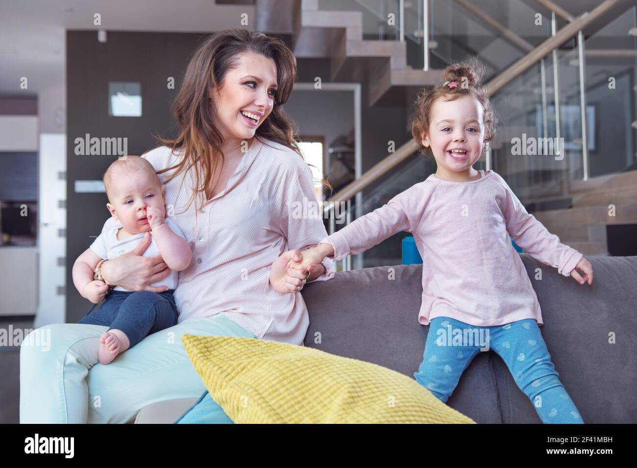 Pretty young mom relaxing with children Stock Photo - Alamy