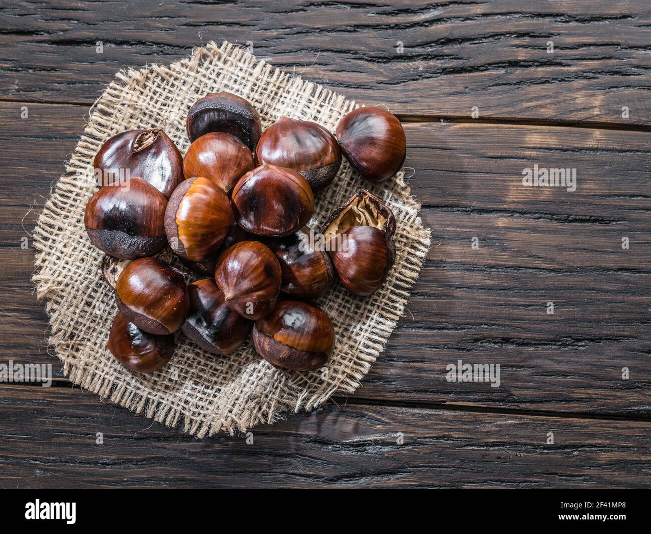 Roasted edible chestnut fruits on wooden table. Top view Stock Photo ...