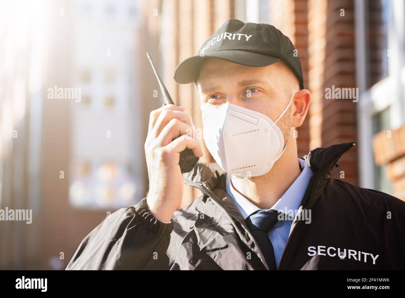 Security Officer In FFP2 Covid Mask Using Walkie Talkie Stock Photo - Alamy