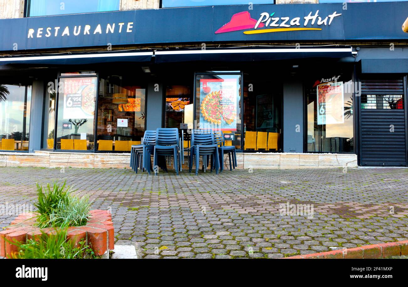 Closed Pizza Hut restaurant with chained chairs on the pavement during ...