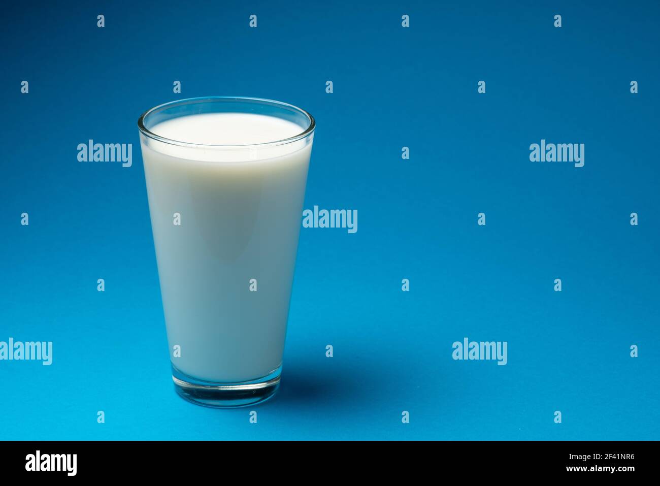 Glass of fresh milk isolated on blue background Stock Photo - Alamy