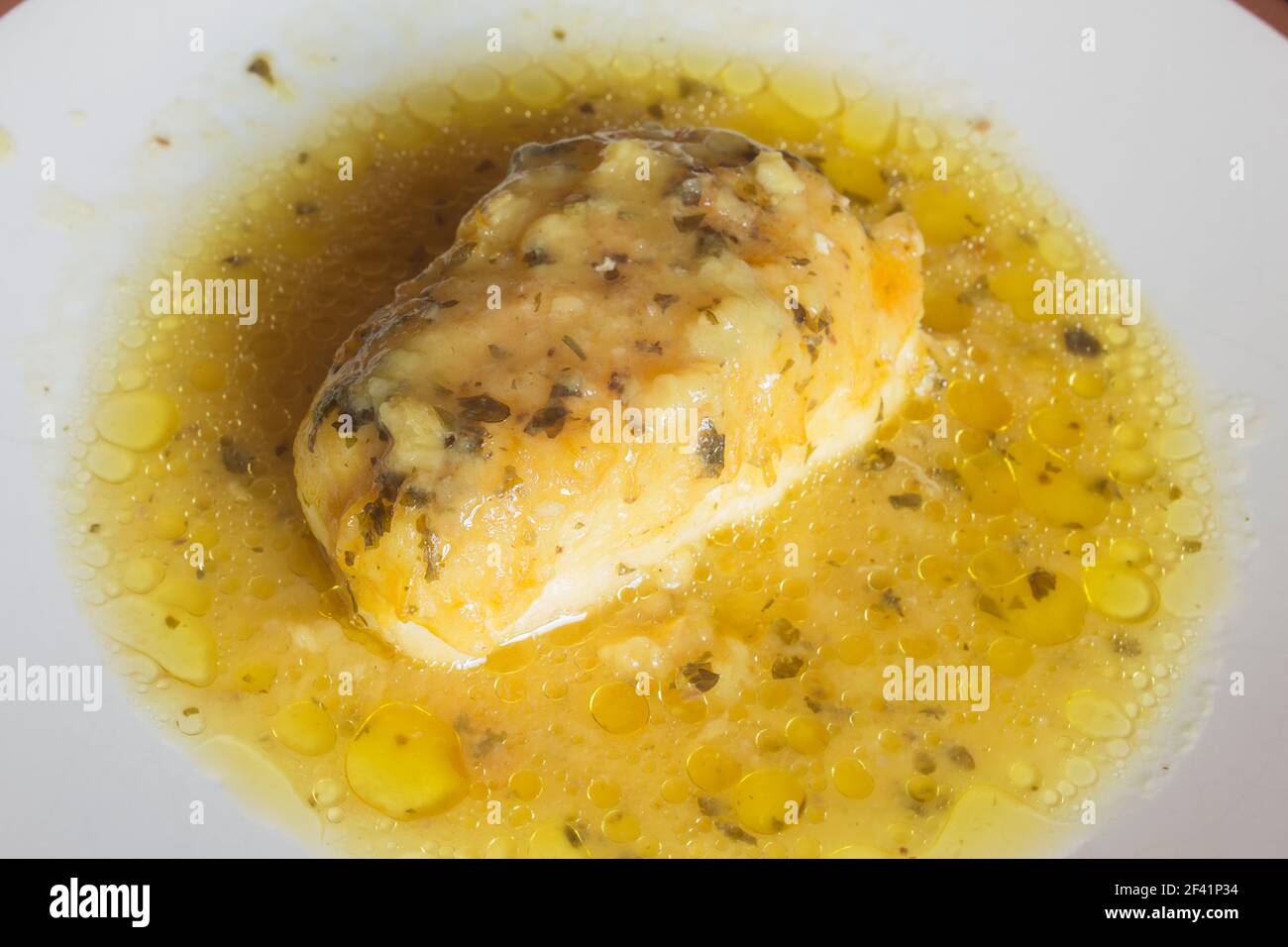 Close-up of a hake loin in green sauce. Cooking recipes with fish and ...