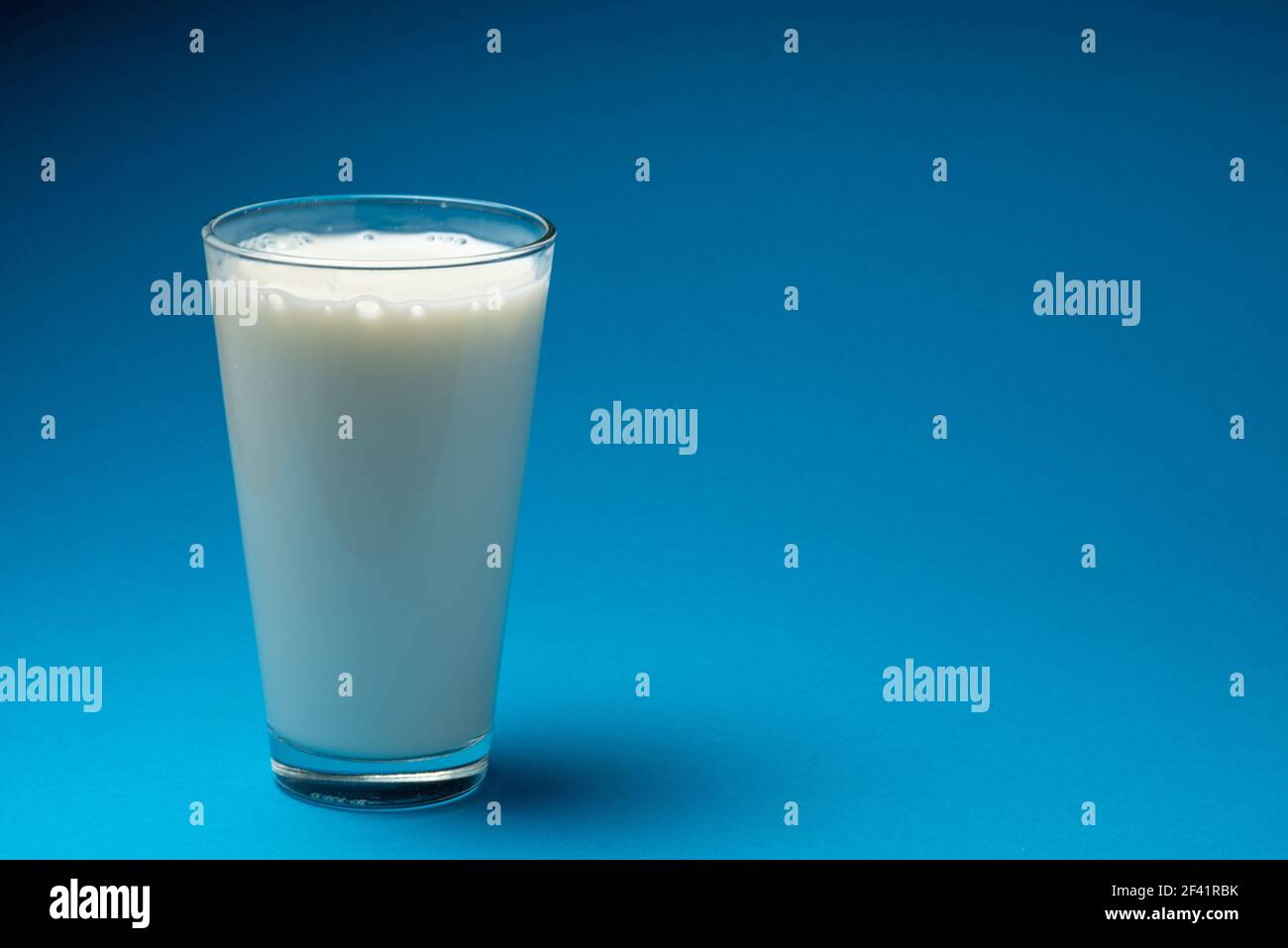 Glass of fresh milk isolated on blue background Stock Photo - Alamy