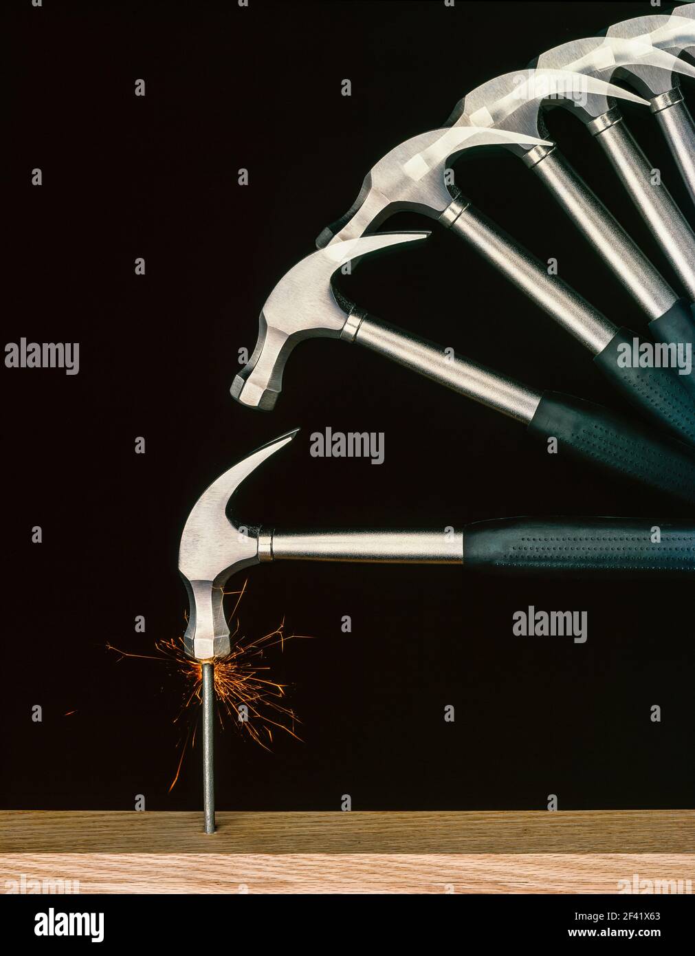 hammer striking the head of a nail producing sparks, multiple exposure ...