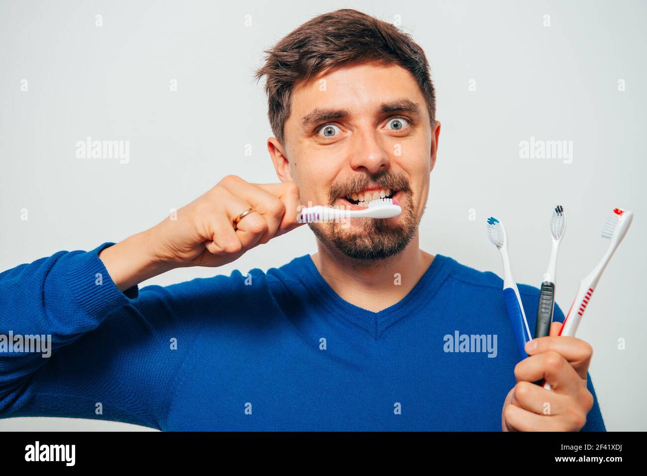 man holding toothbrushes Stock Photo - Alamy