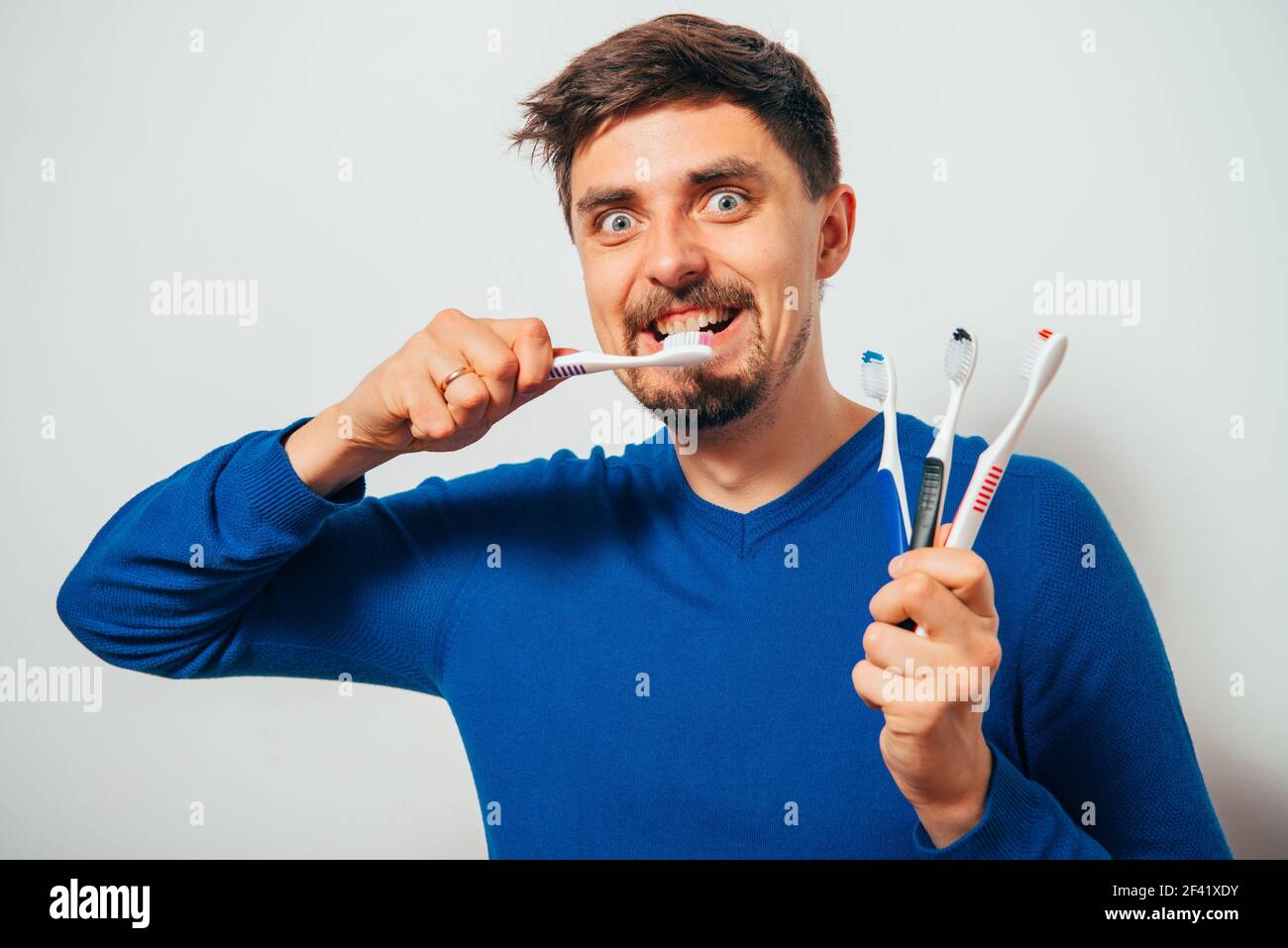 man holding toothbrushes Stock Photo - Alamy