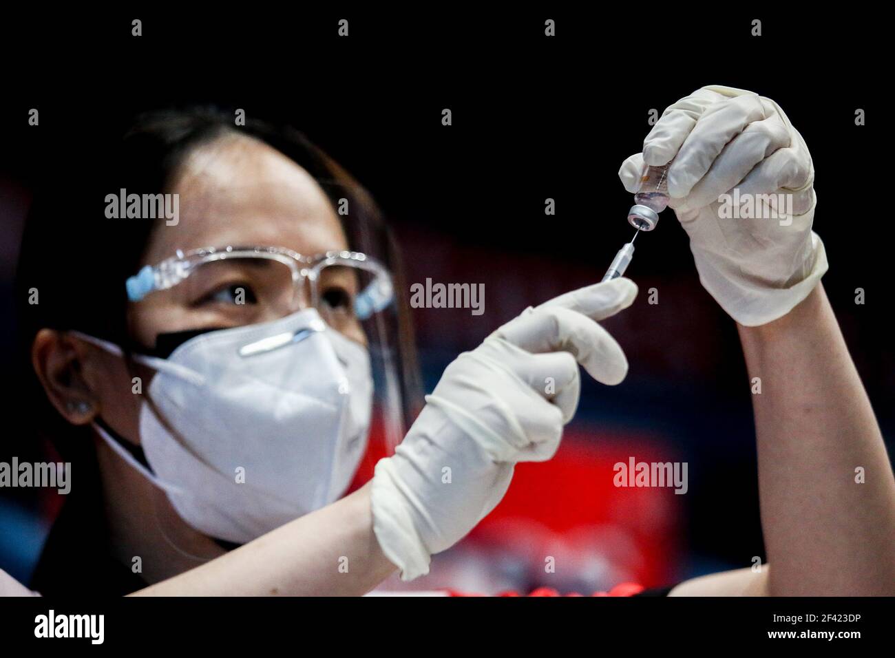 A health worker prepares to inoculate a dose of the Sinovac COVID-19 ...