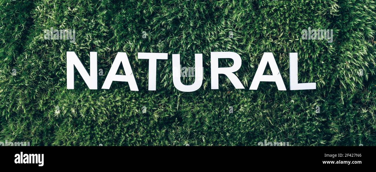 Word Natural on moss, green grass background. Top view. Copy space ...