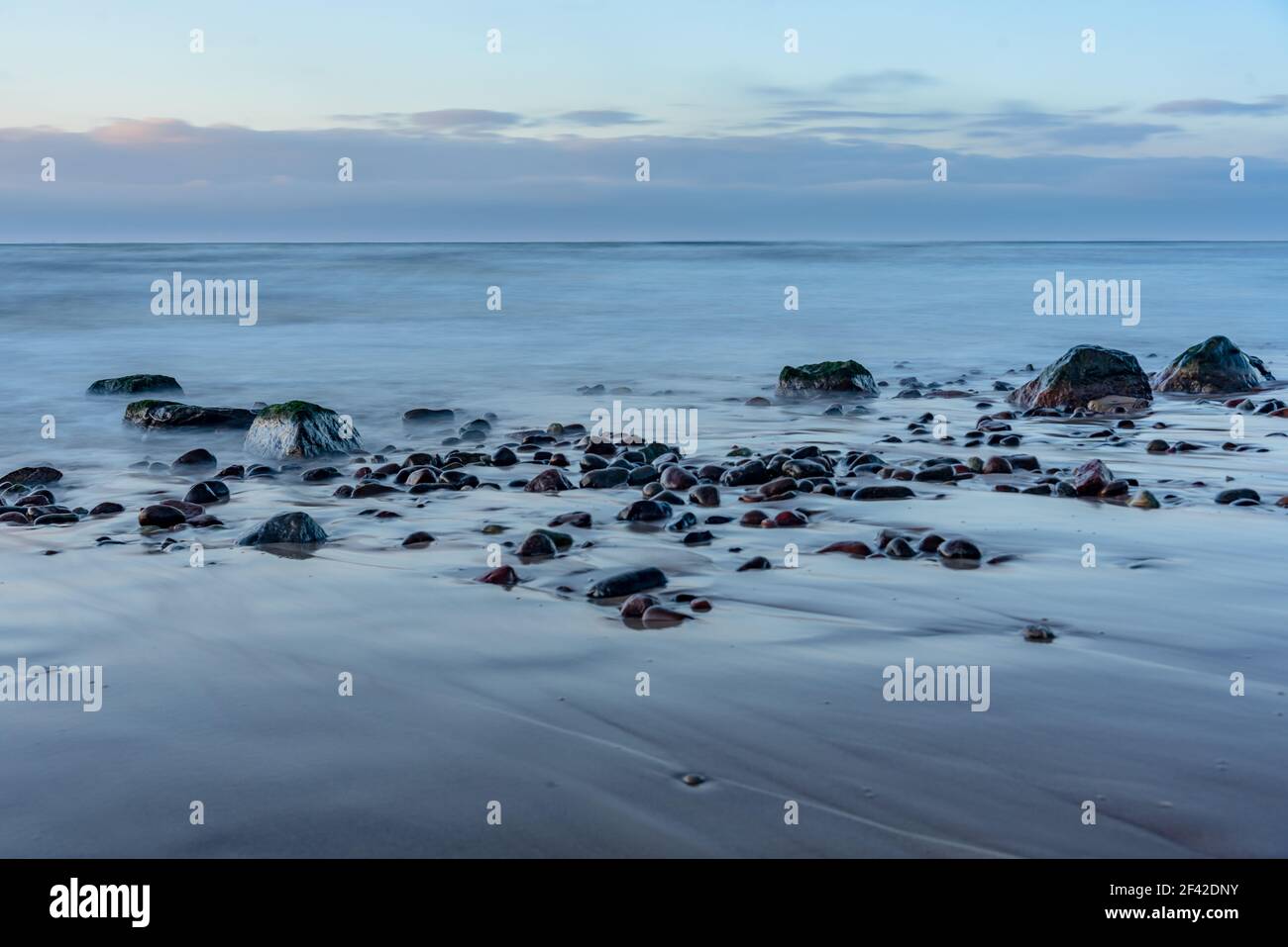 on the water shore large and small stones water washed and clouds on ...