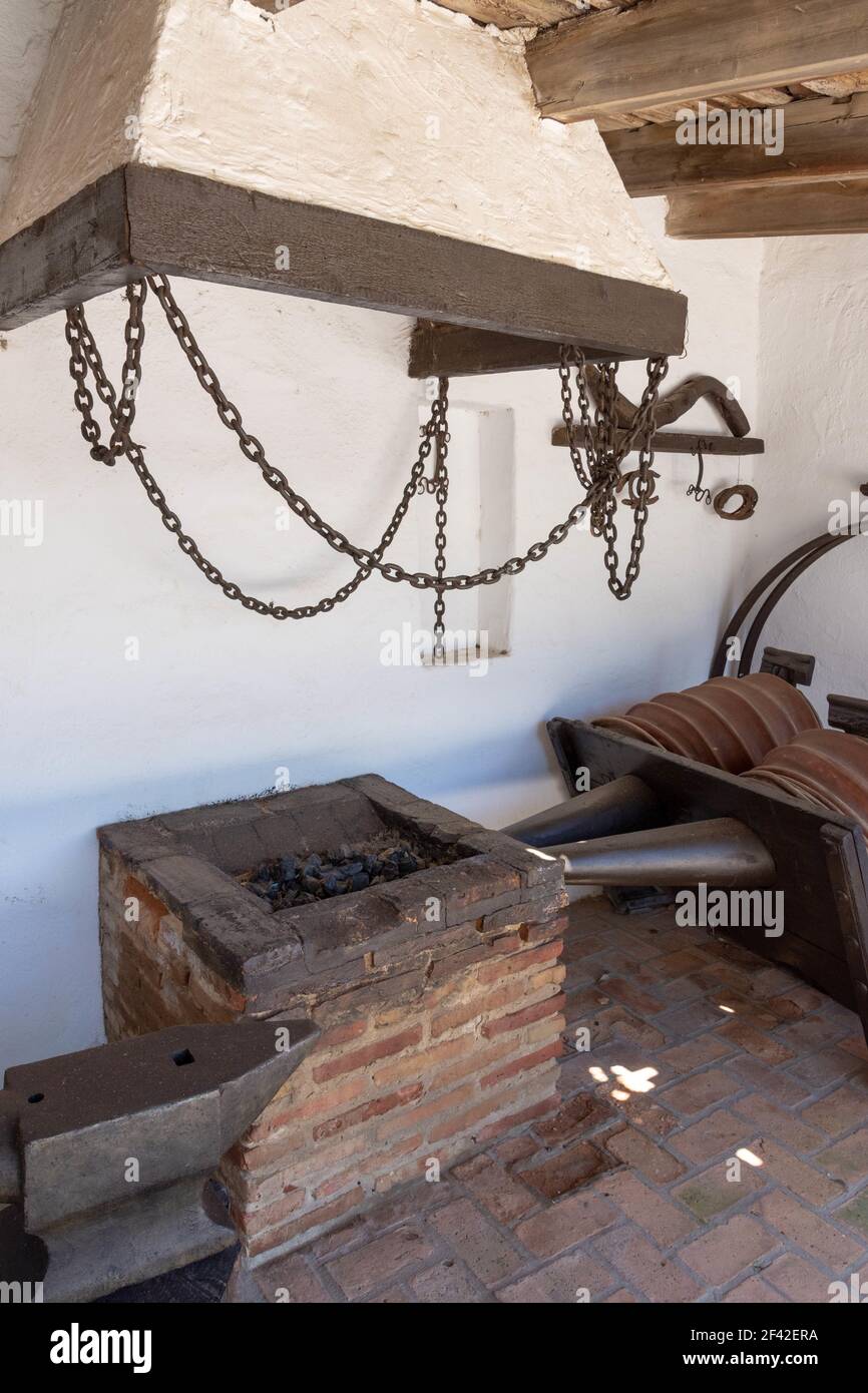 A vertical shot of an anvil, chimney and a forge in a smithy in Huelva ...