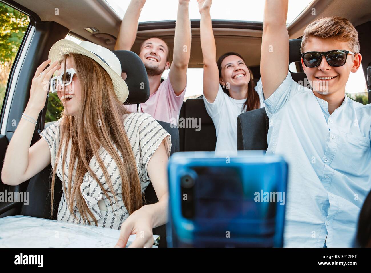 four friends in car navigation on phone. road trip Stock Photo - Alamy