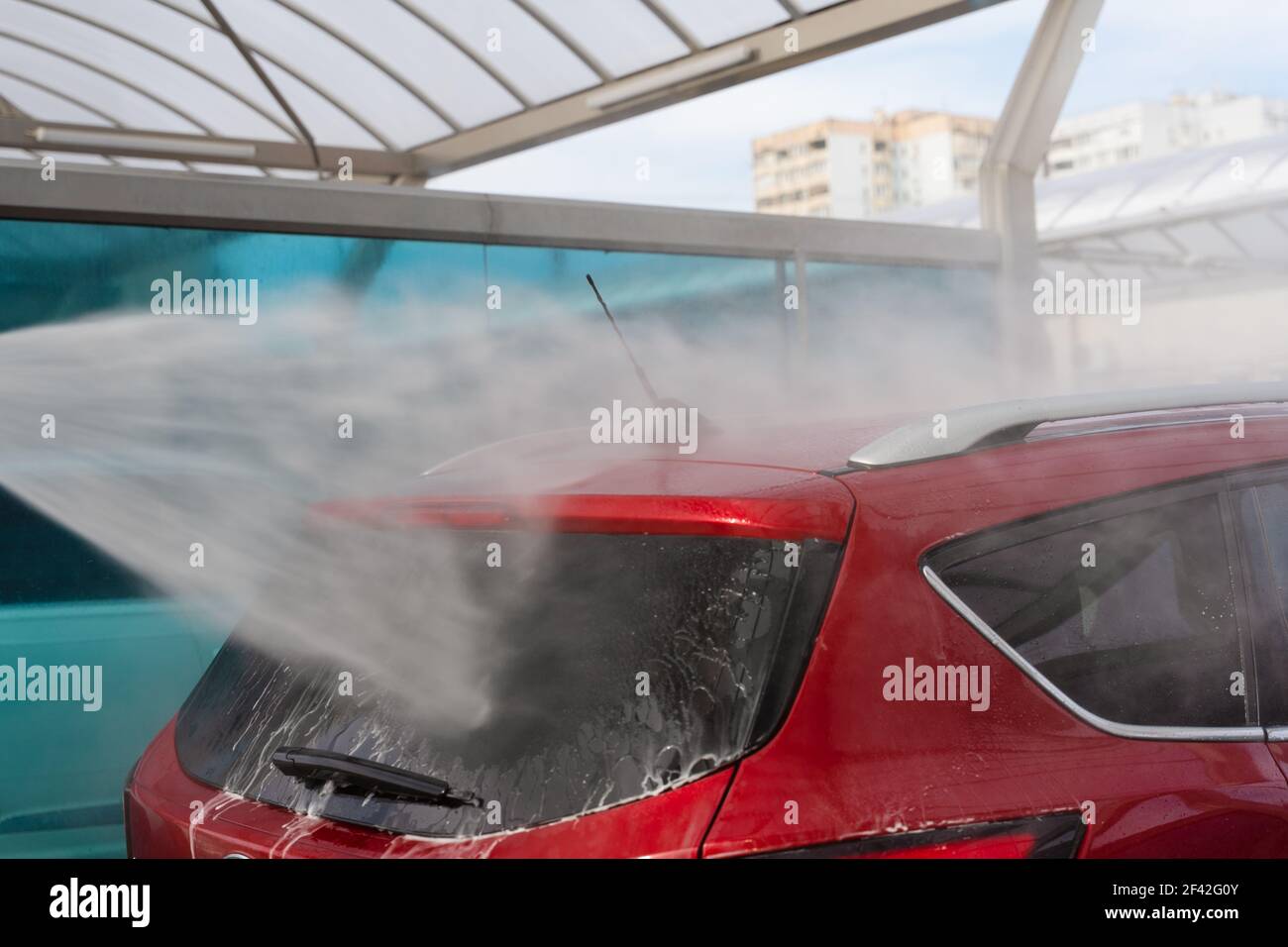 washing car at autowash . Car wash. red machine under the pressure of ...