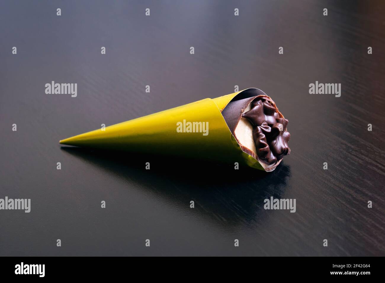 Chocolate candy in a yellow wrapper on a wooden table Stock Photo - Alamy