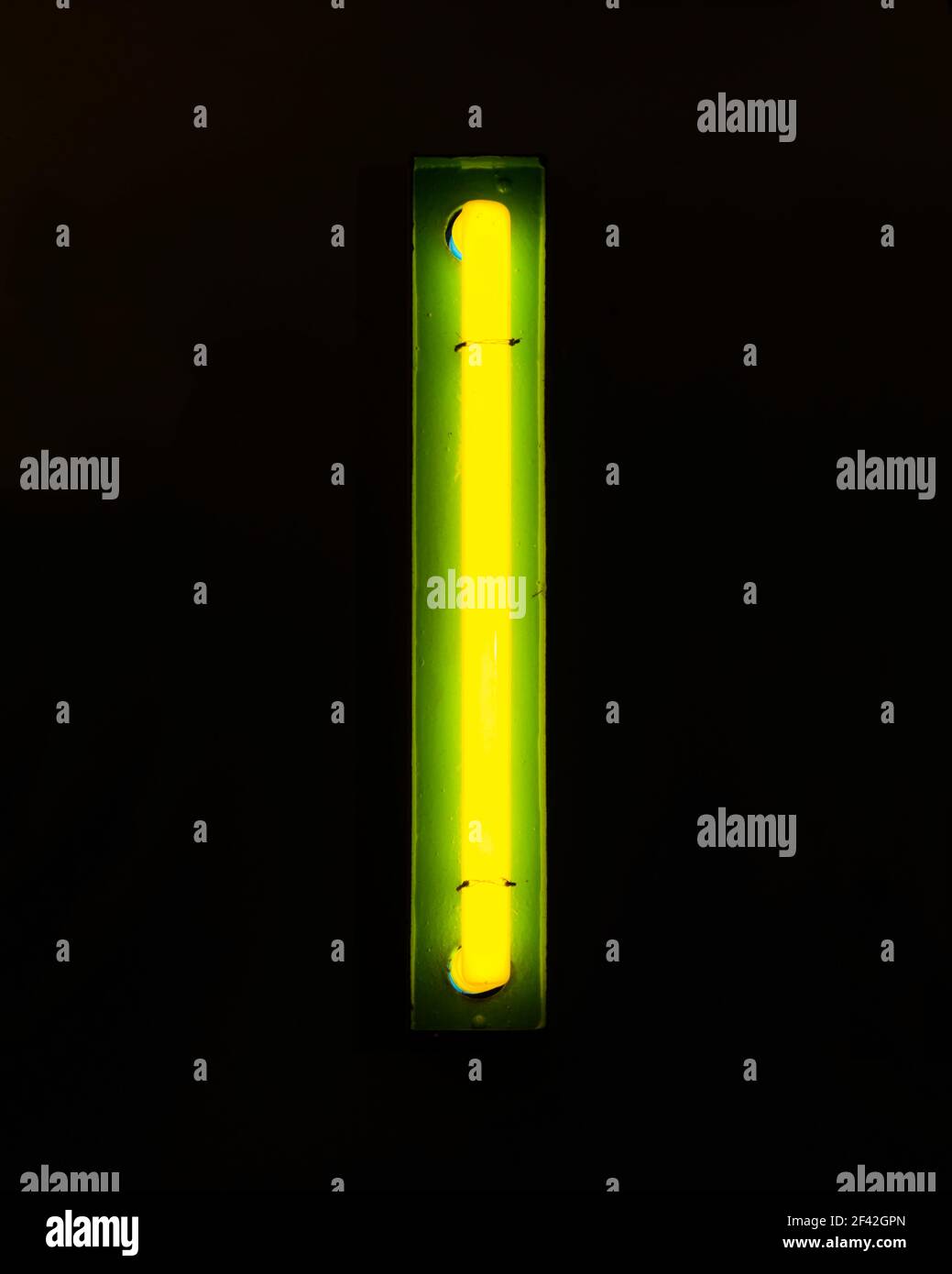 Yellow neon letter I glowing in the dark Stock Photo - Alamy