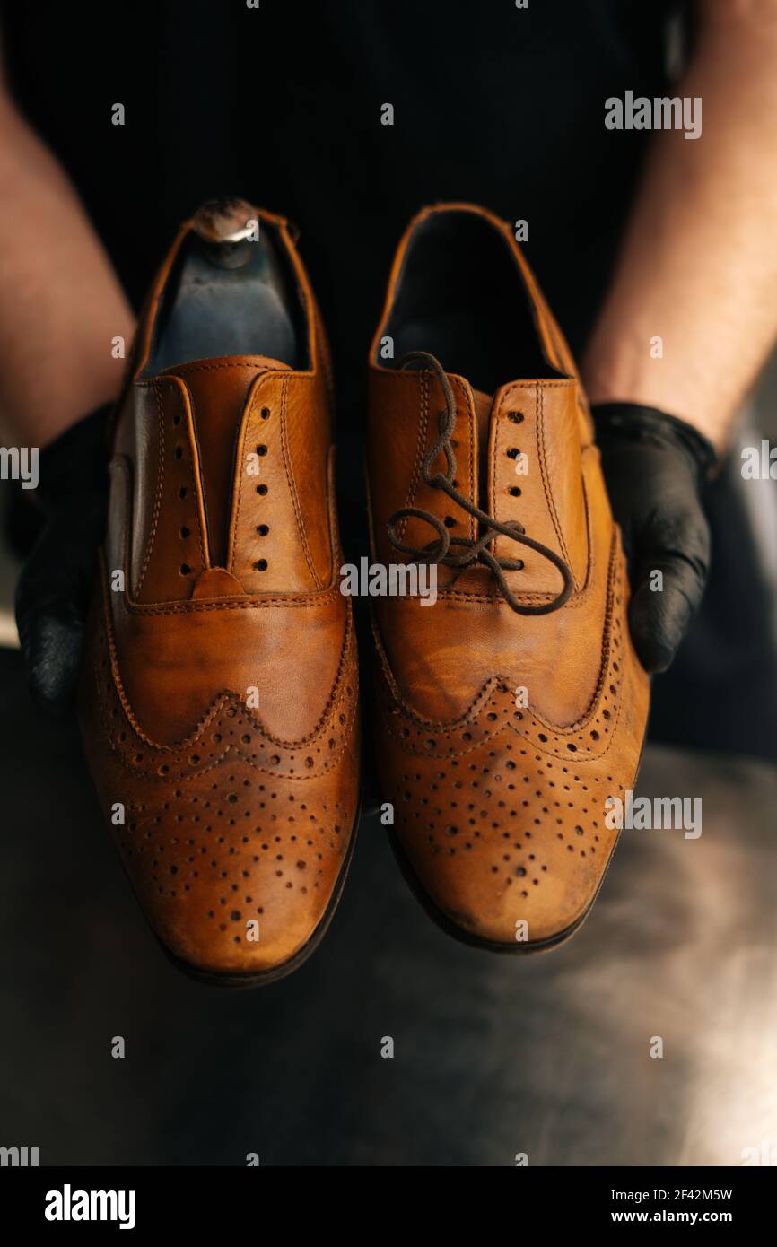 Close-up top view of hands of shoemaker shoemaker in black gloves ...