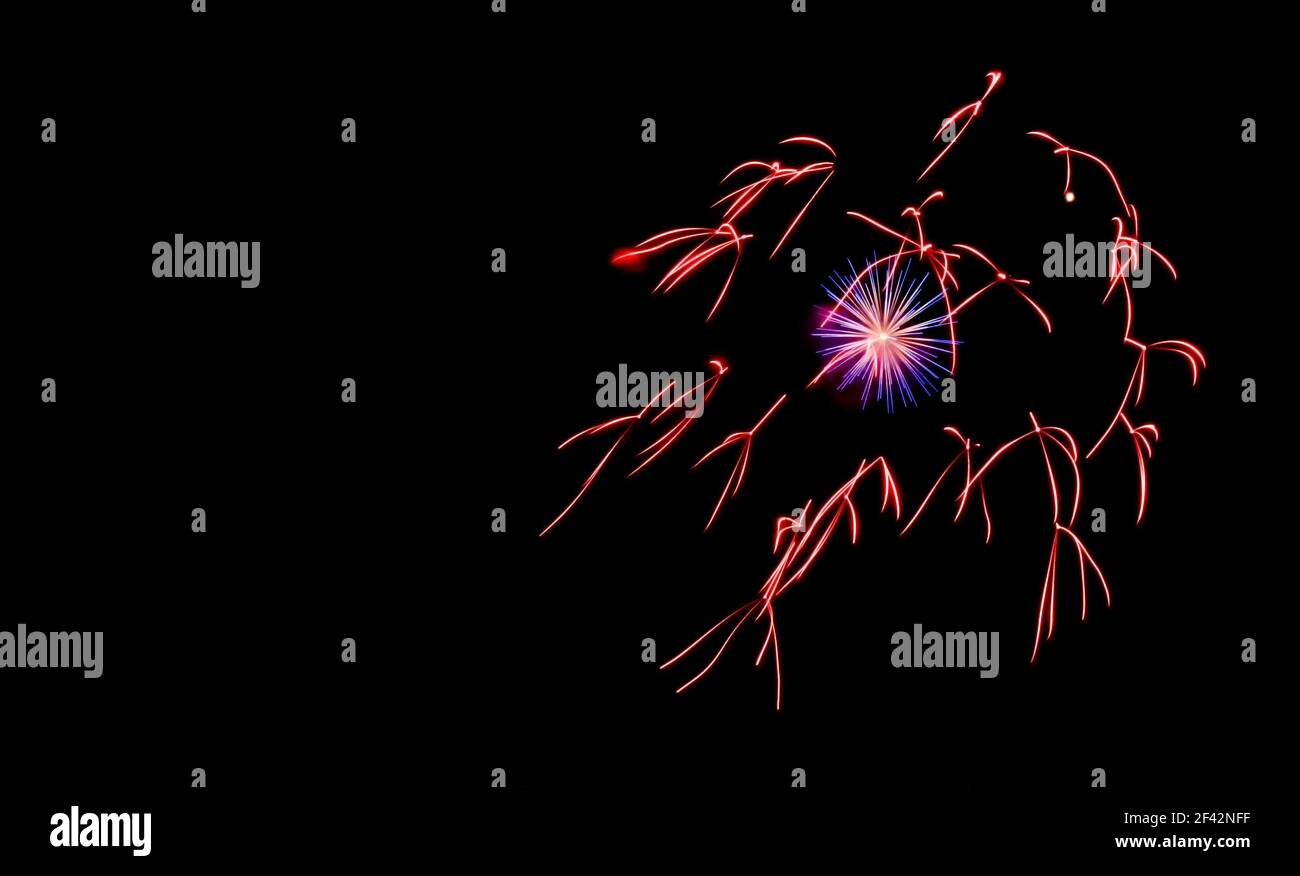 Closeup of fireworks in the sky. Red and blue streamers. Short exposure ...