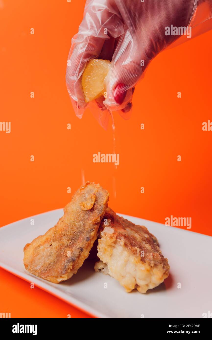 Battered fish fillet isolated over red background Stock Photo - Alamy
