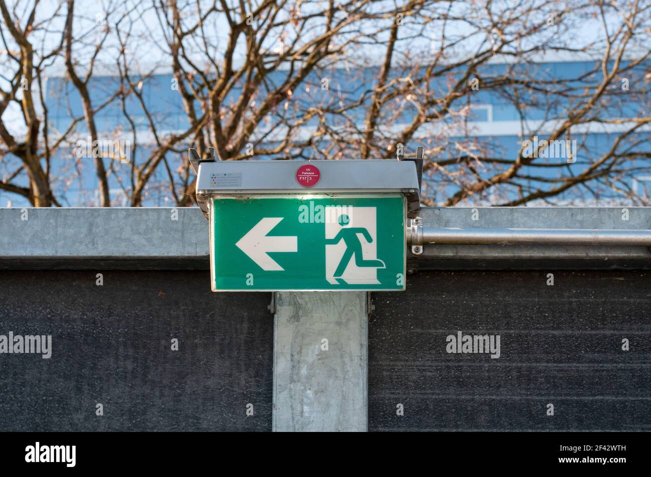 an emergency exit sign at a parking lot with a running stick figure and ...