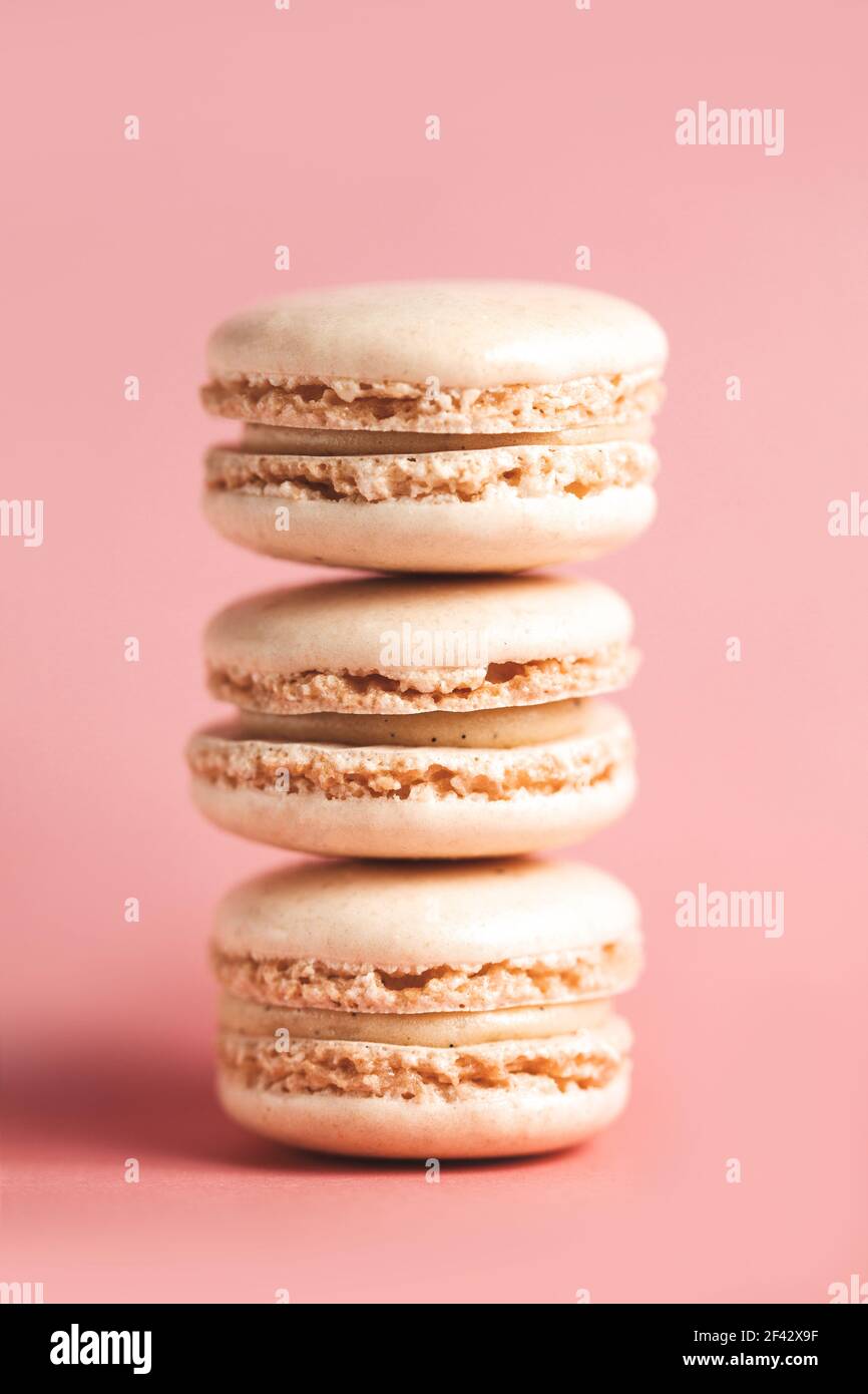 Tower of three light colored macaroons on pink background Stock Photo ...