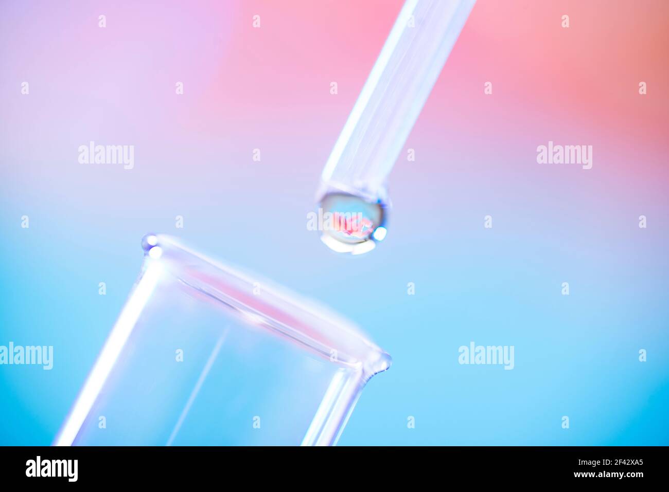 Chemical test tube and pipette with a drop of colorless liquid close up ...