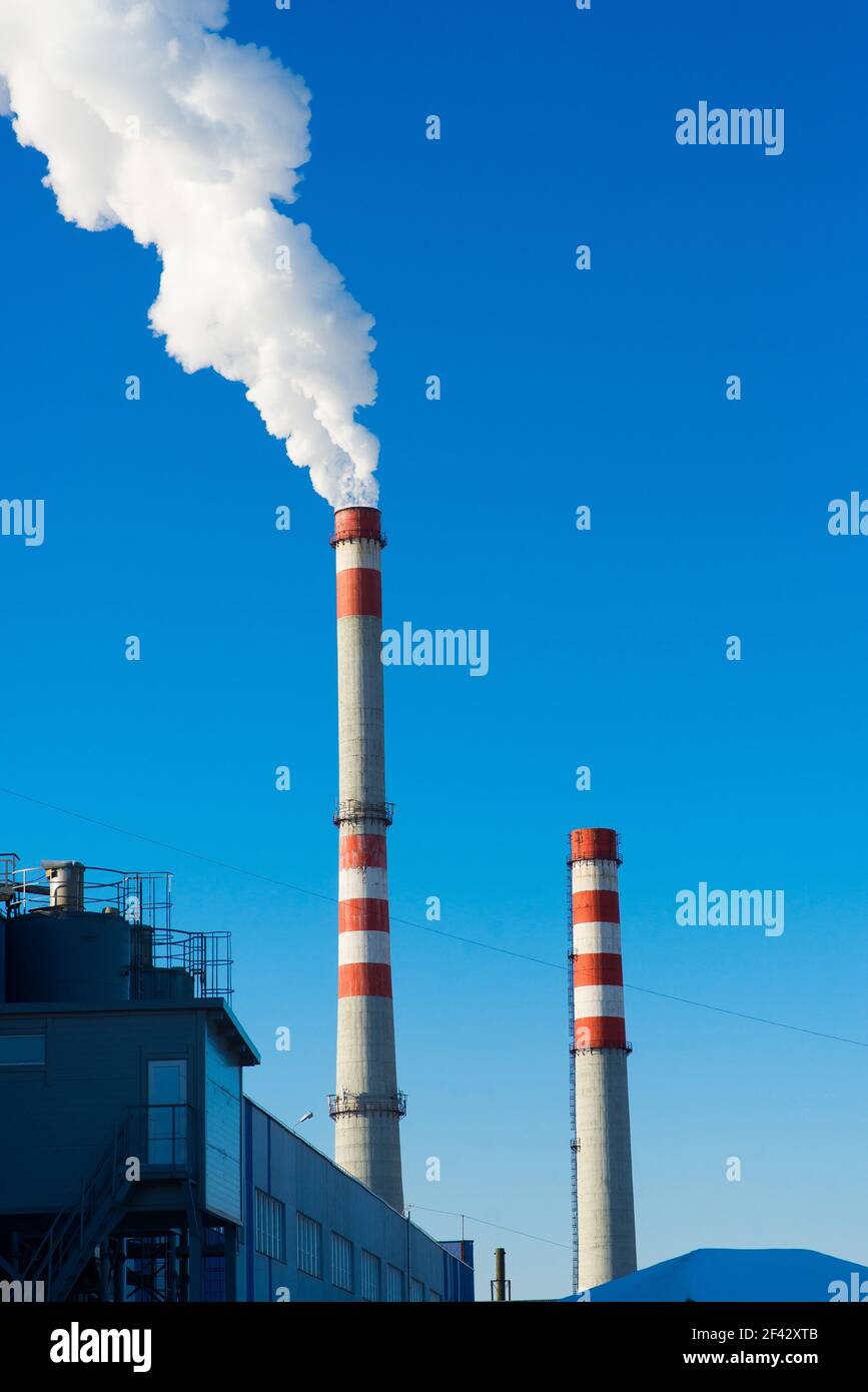 Industrial landscape, cranes, pipes with smoke. Air pollution from ...