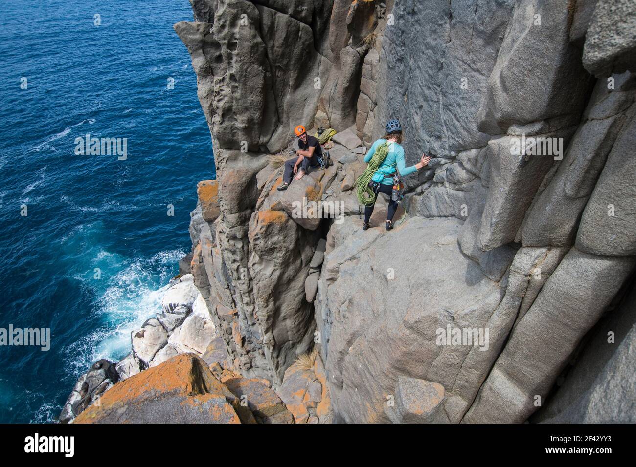 A couple of intrepid rockclimbers explore the featured sea cliffs of ...
