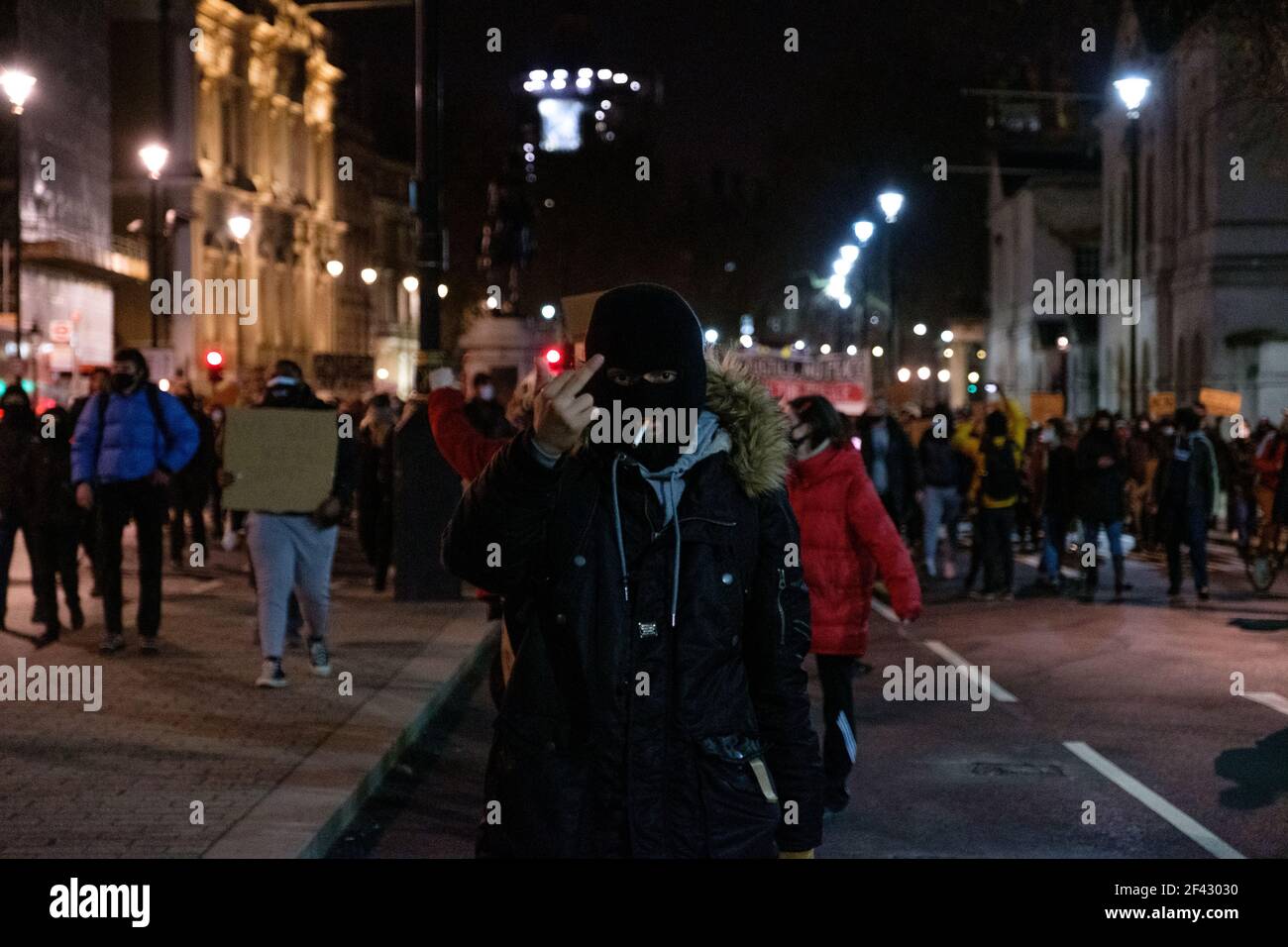 London, UK. 16th March, 2021. Protester wearing a balaclava giving the ...