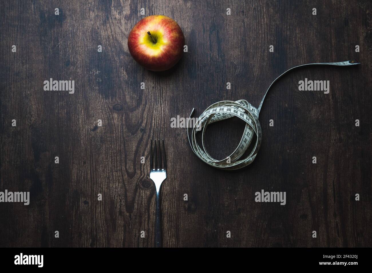 Apple with meter on wooden background Stock Photo - Alamy