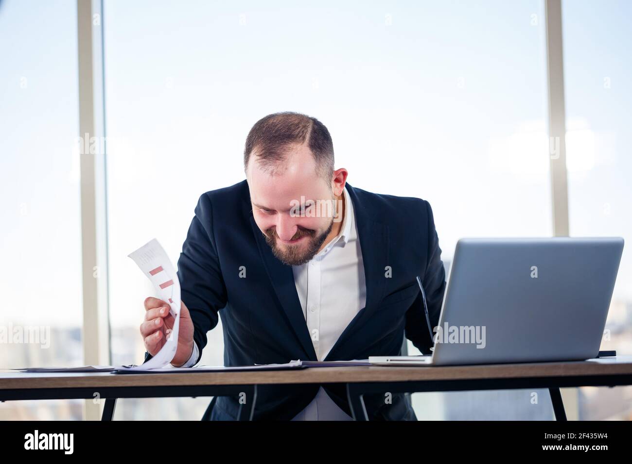 The corporate madman is sitting at the computer in the office and going ...