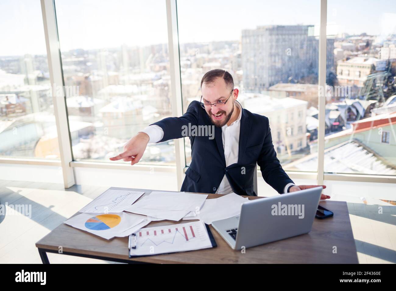 The corporate madman is sitting at the computer in the office and going ...