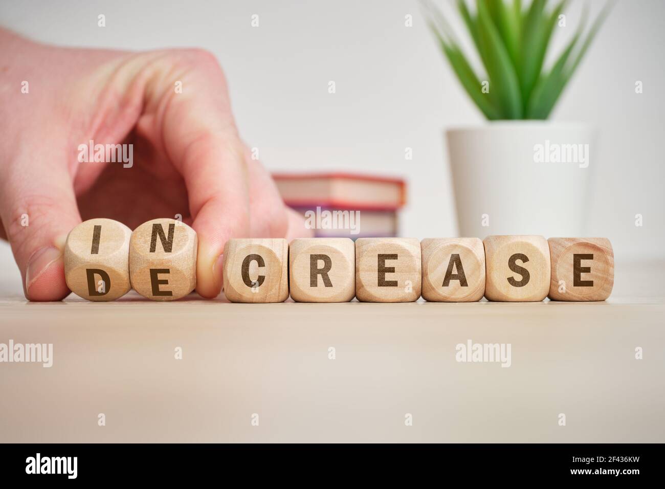 The concept of choice increase and decrease on wooden cubes is turned over by hand Stock Photo ...