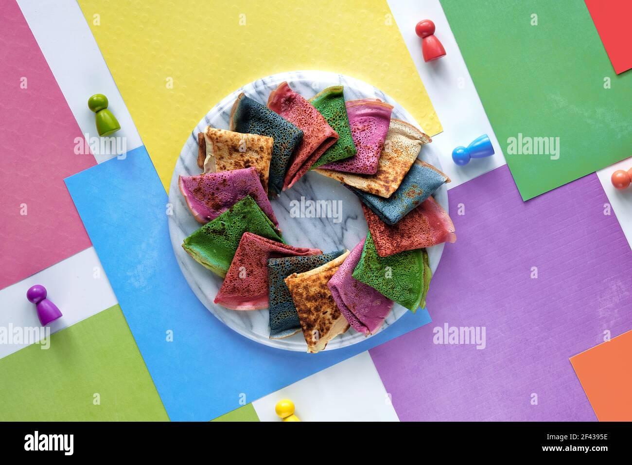 Plate of crepes in colors of the rainbow on layered rainbow paper ...