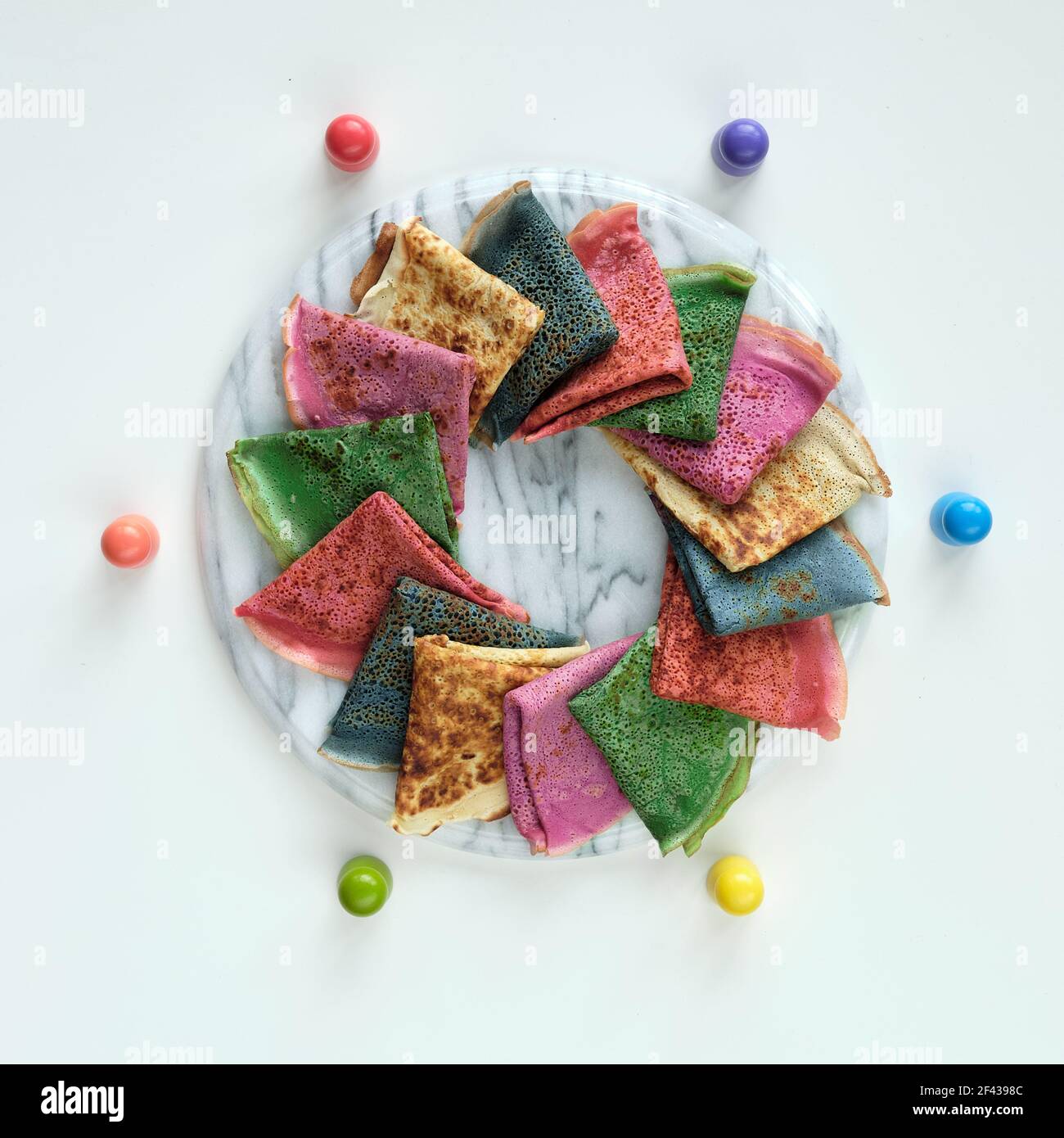 Rainbow party, table setup. Vibrant crepes on marble table with wood ...