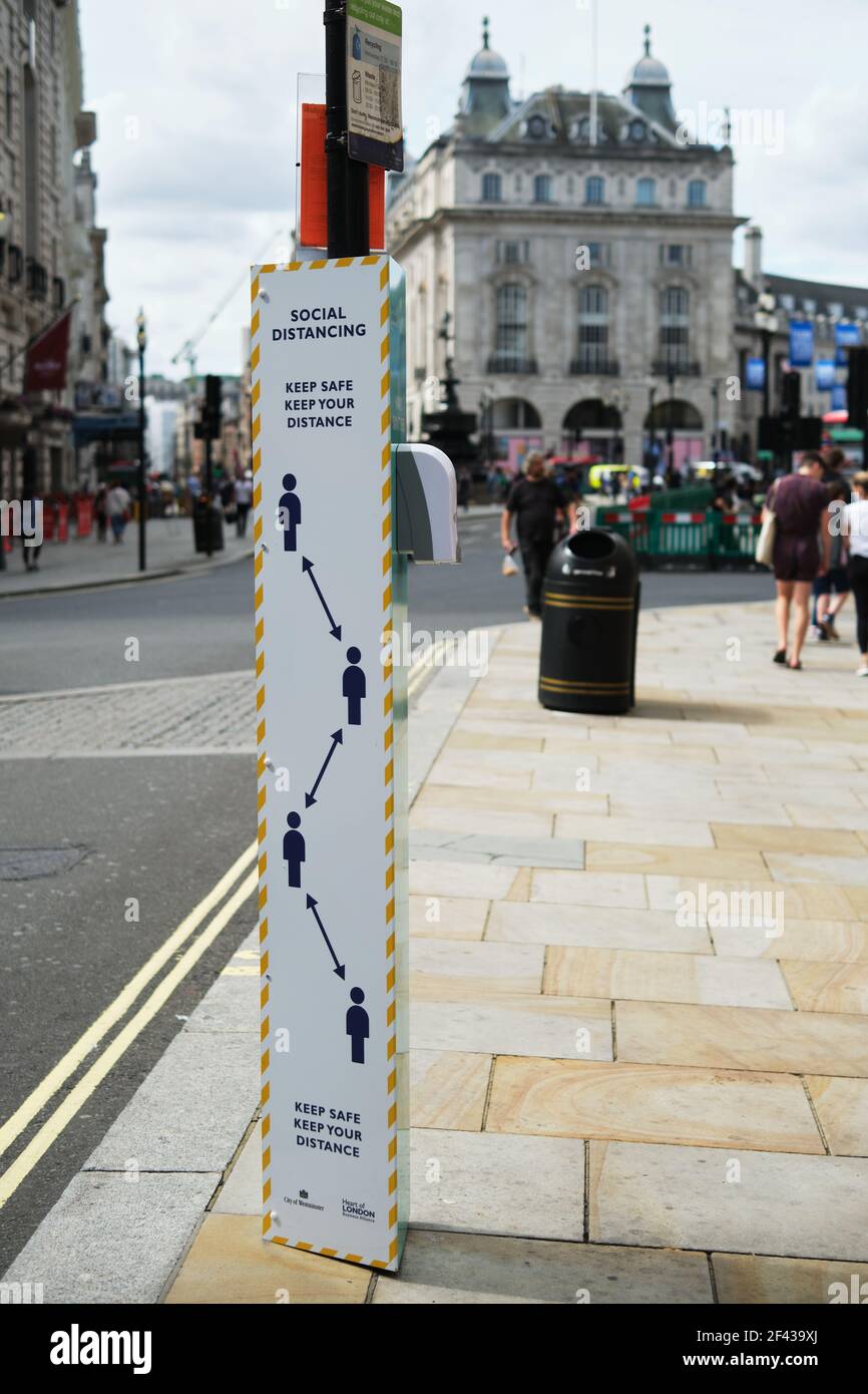Social distance sign on a lamppost in Piccadilly Circus Stock Photo - Alamy