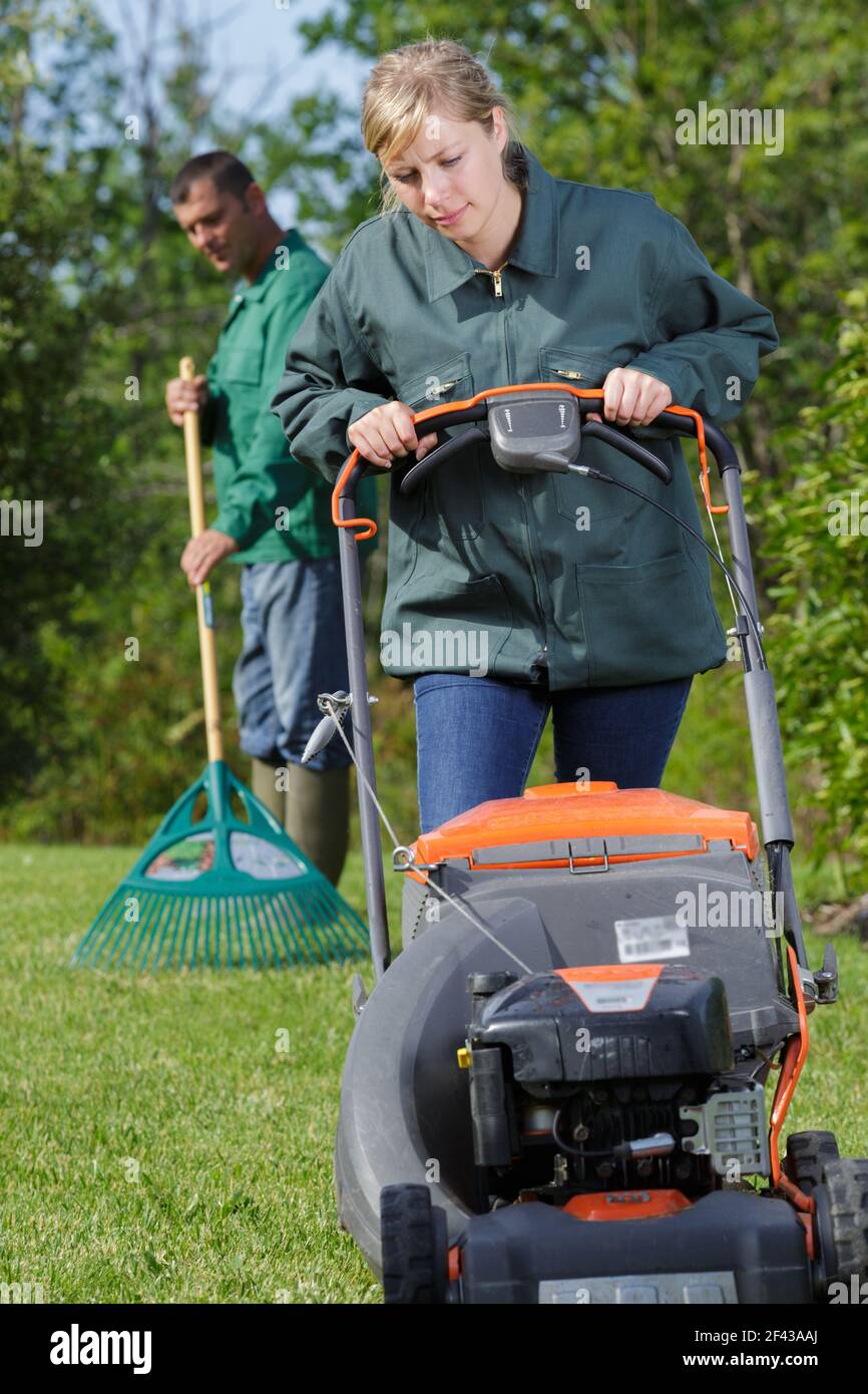 professional gardening team using rake and mower Stock Photo - Alamy