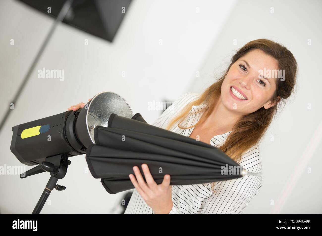 young creative photographer controlling the light at the studio Stock ...