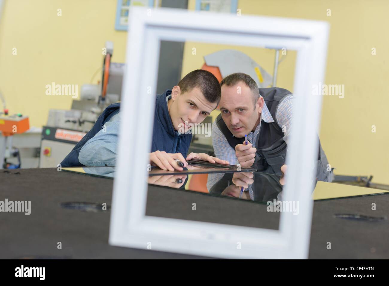 young guy worker is inspecting the window frame in workshop Stock Photo ...
